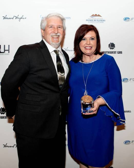 Larry Simon and Traci Sexton Hall of Tri Pointe Homes show off an award ...